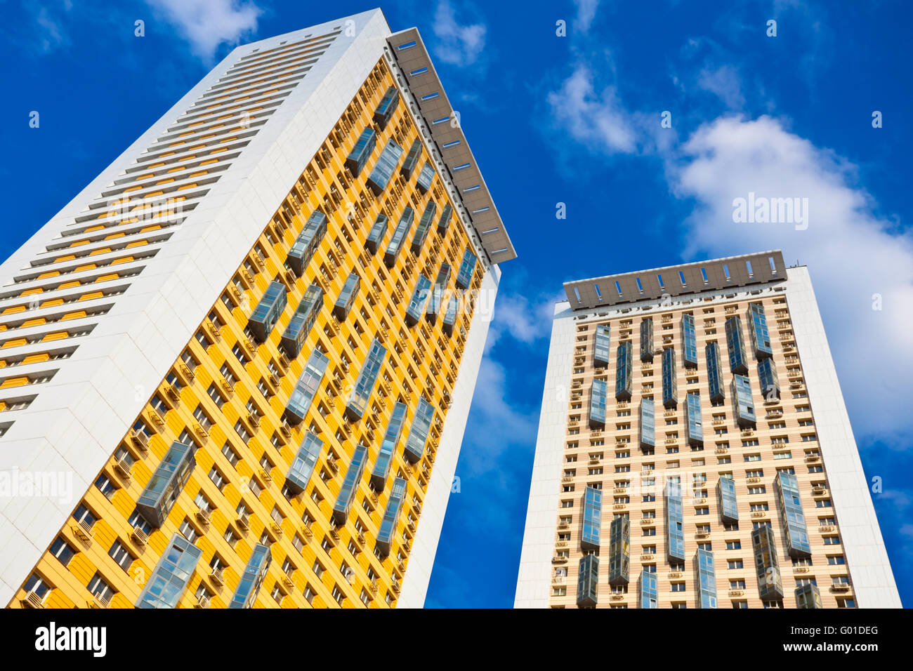 New yellow dwelling towers with balconies against blue sky Stock Photo ...