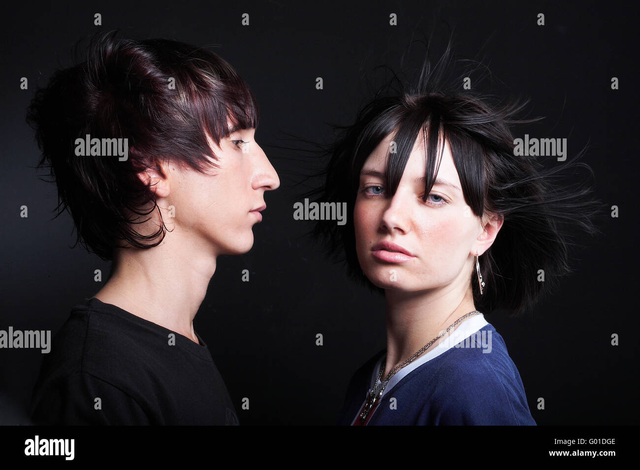 Cute young couple with fashion haircut, on black Stock Photo - Alamy