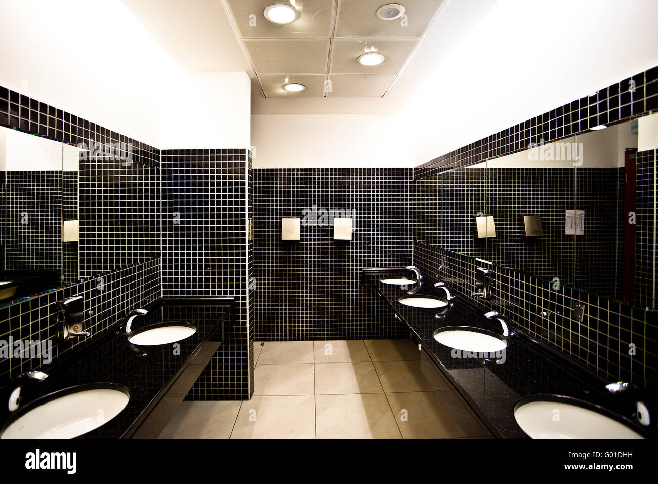 Empty restroom interior in brown and white with washstands Stock Photo ...