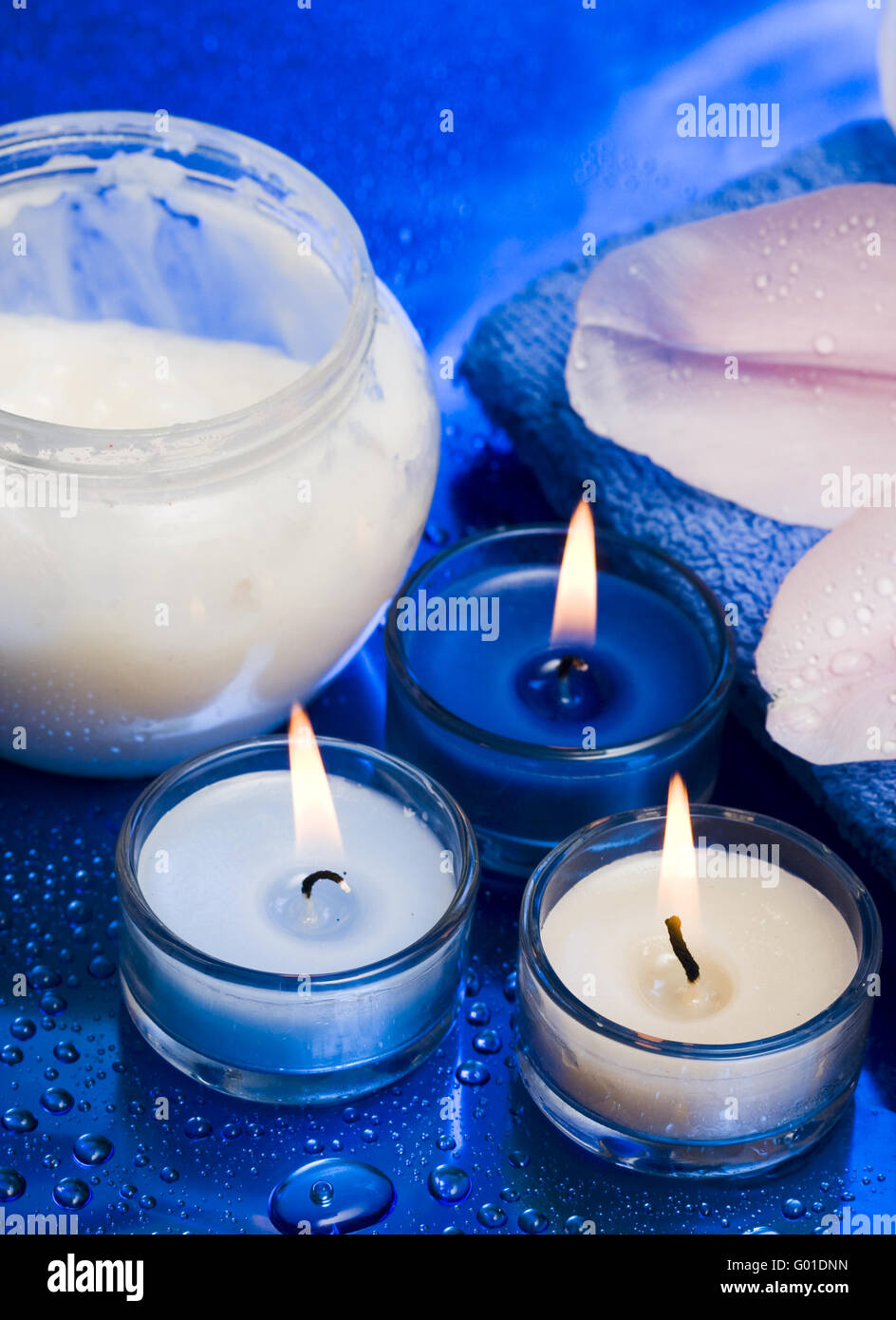 spa essentials, cream, candles with flower on blue background Stock ...
