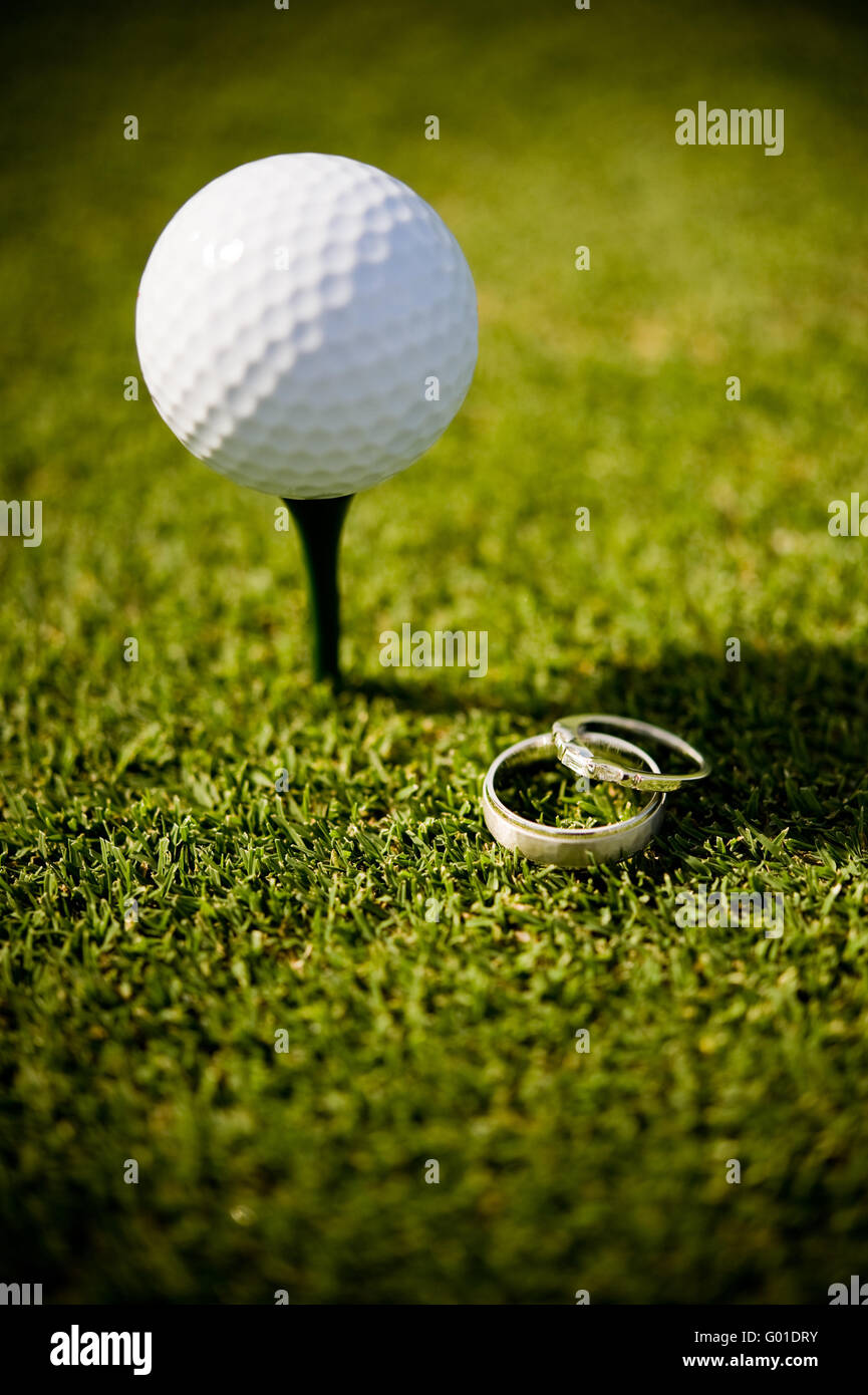 Wedding rings lying on a golf green next to a ball Stock Photo - Alamy