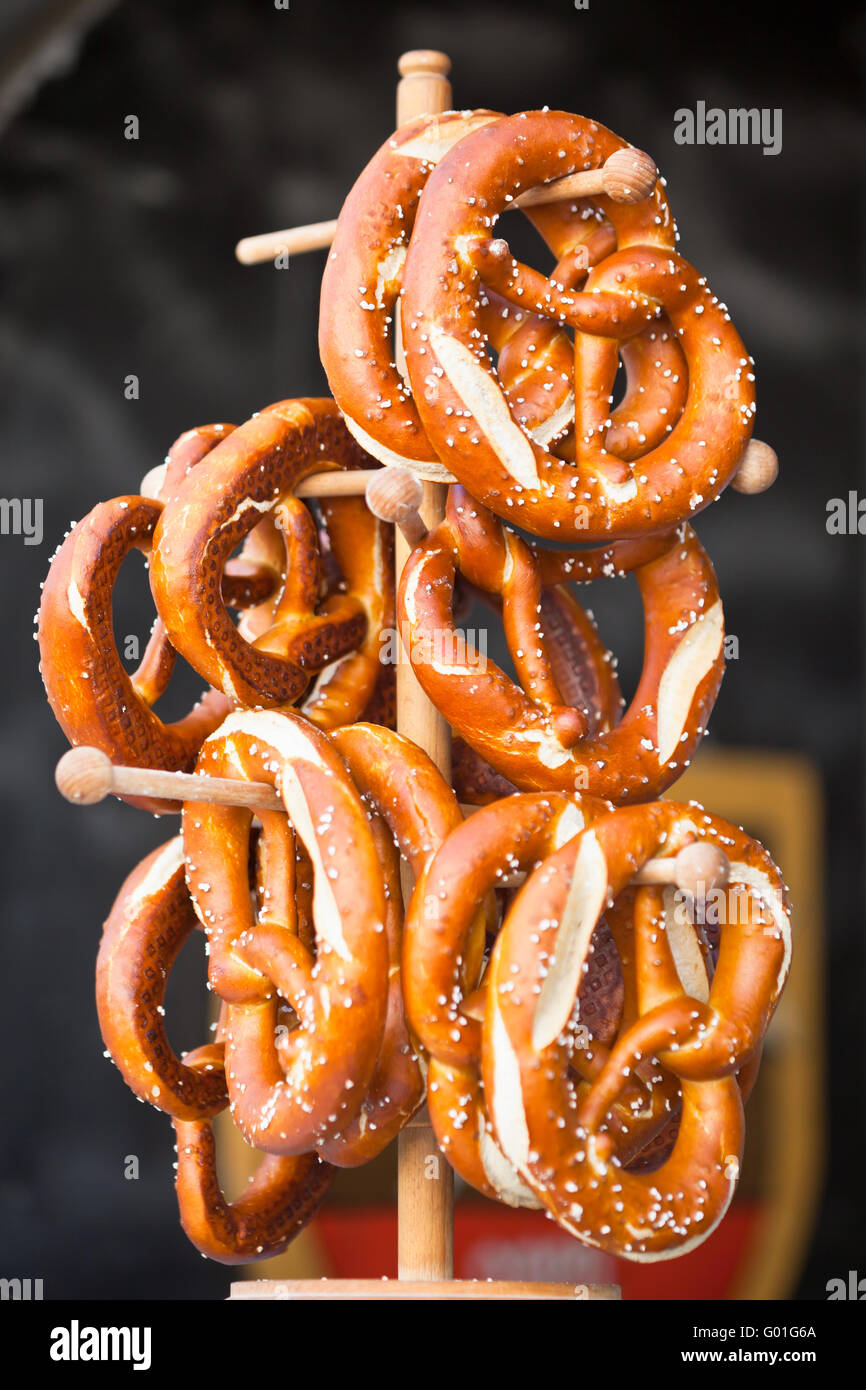 Pretzels - traditional german snacks are hanging on the wooden stand ...
