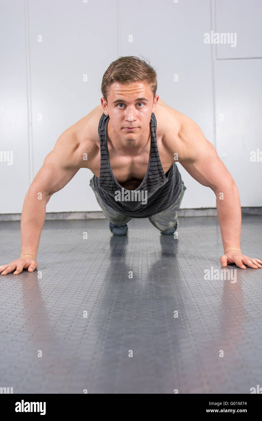 Young man performing push ups at the gym Stock Photo - Alamy