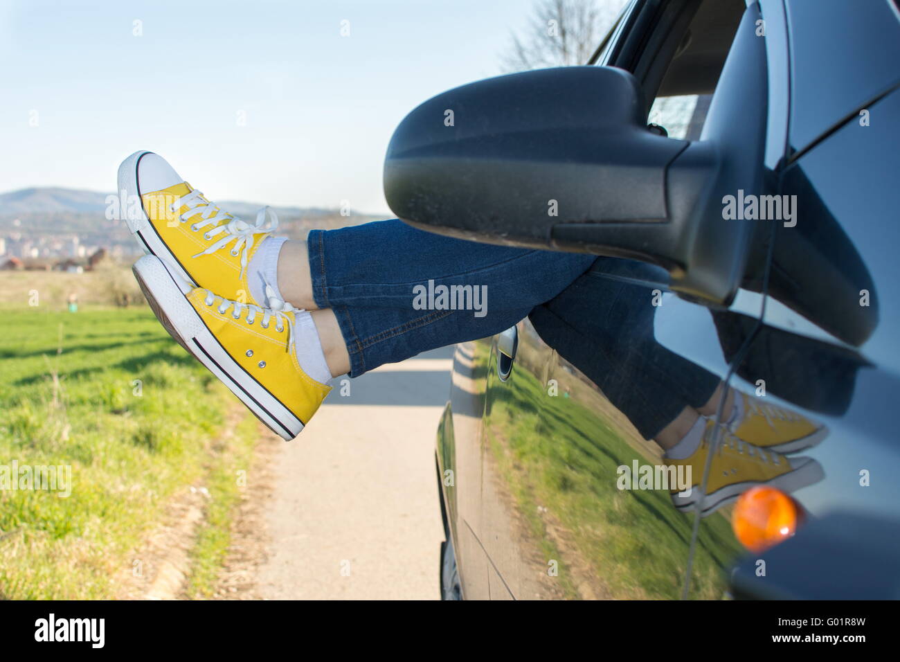 Woman legs out of the car window. Travel and fun Stock Photo - Alamy