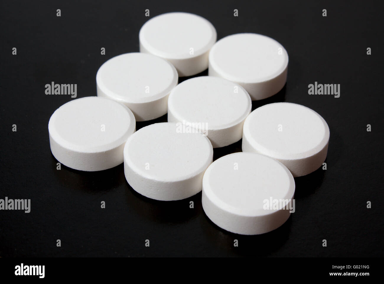 abstract logo of white tablets on black background Stock Photo - Alamy