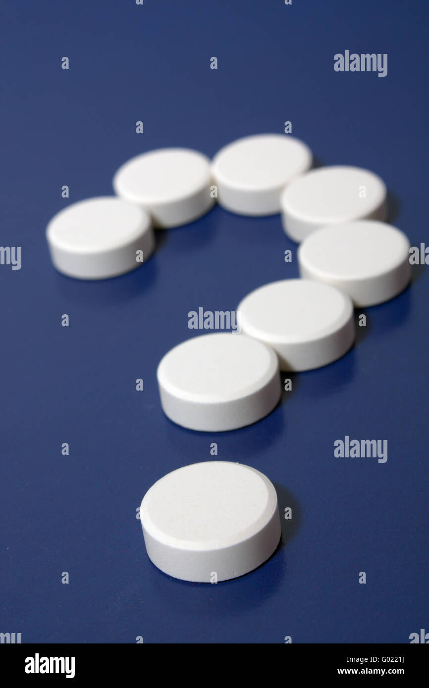 Question mark of white tablets on dark blue background Stock Photo - Alamy