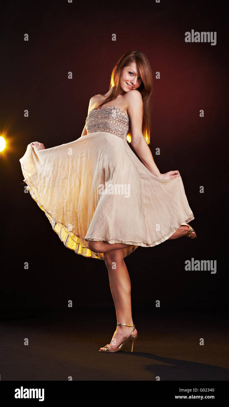 Beautiful young female wearing dress, dancing on dark background Stock ...