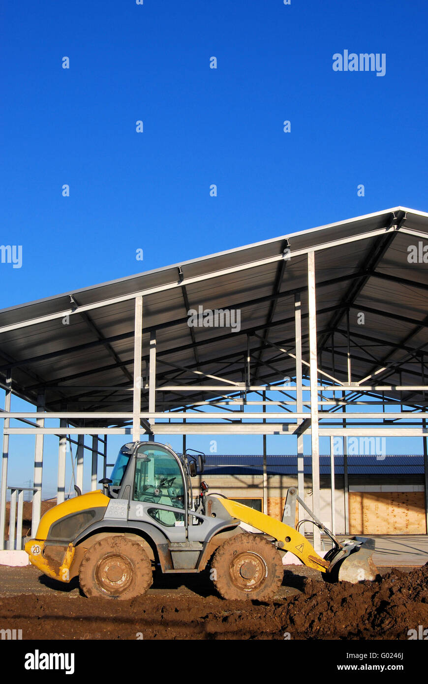 Yellow earthmover in front of a construction site Stock Photo - Alamy