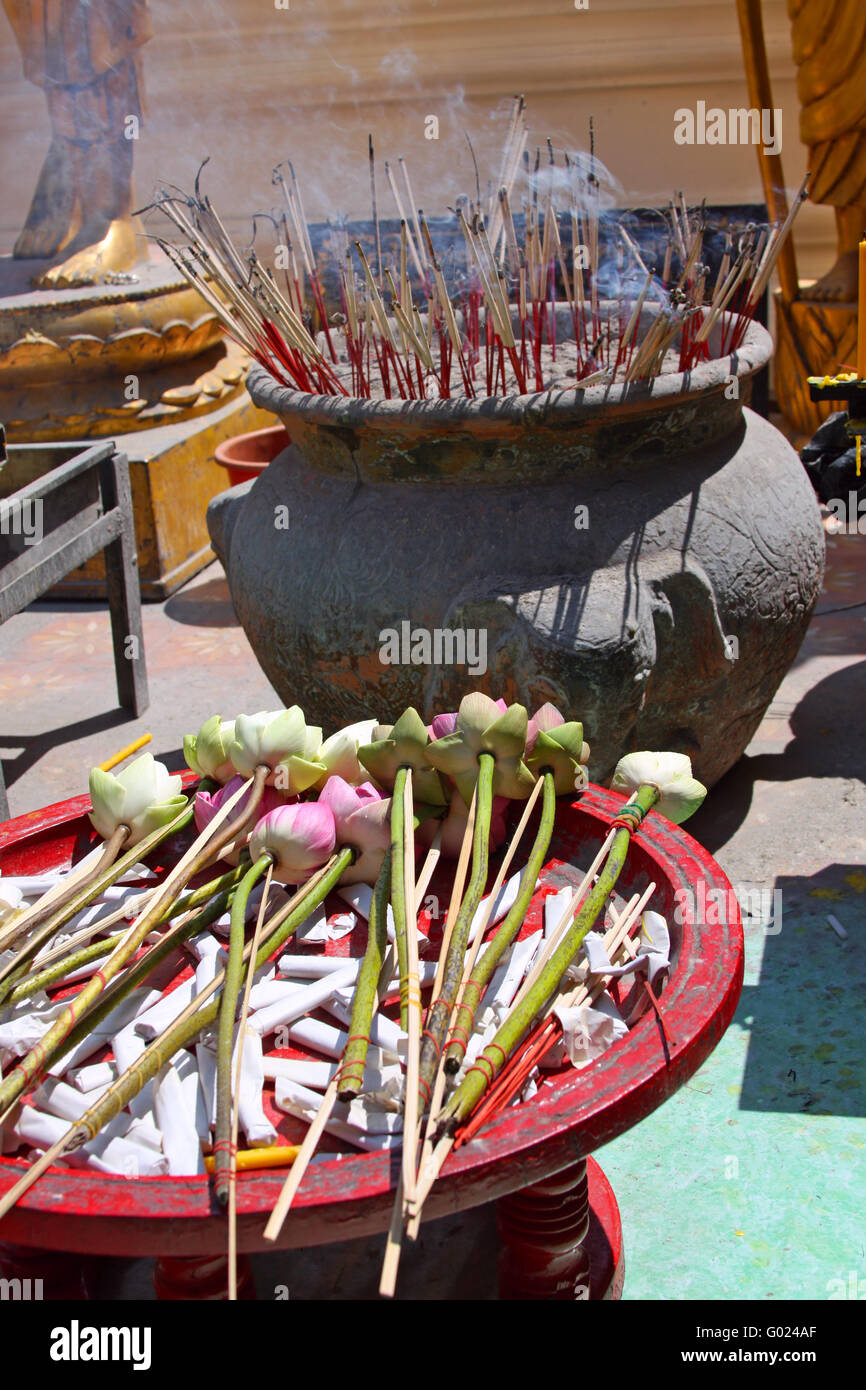 Offering in a Buddhist temple - lotus flowers and incense sticks Stock ...