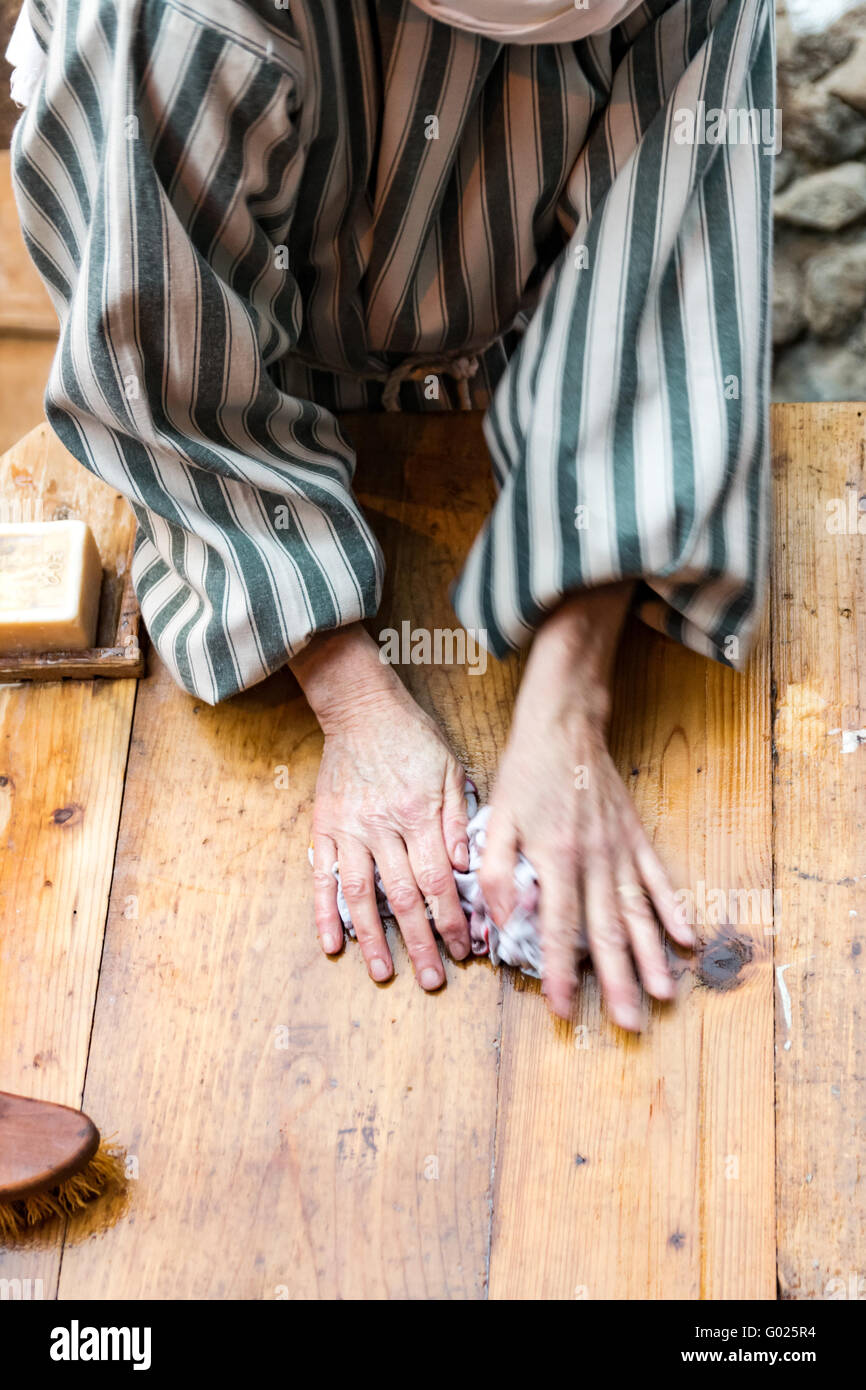 Detail of the hands of a washerwoman washing clothes on a wooden board ...