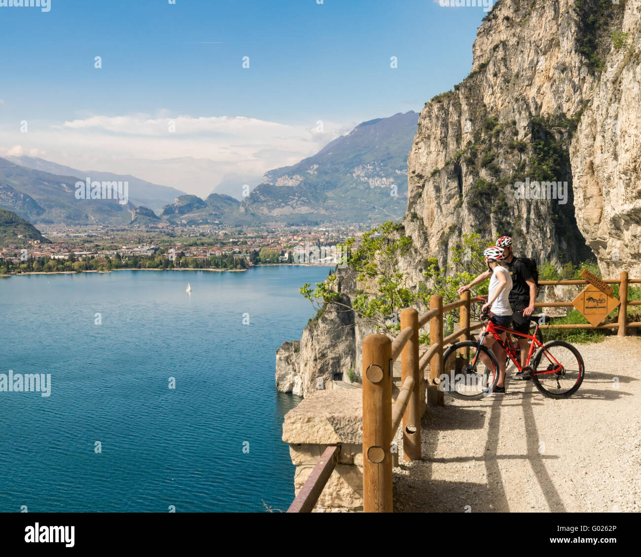 Two cyclists look the panorama from the Ponale trail in Riva del Garda ...