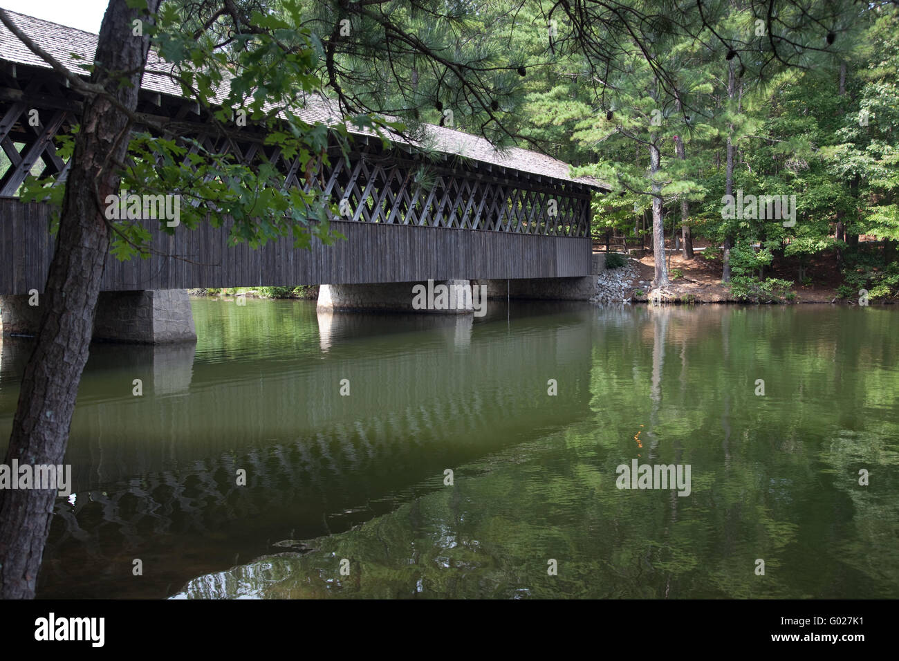 Wooden covered bridge over a lake Stock Photo - Alamy