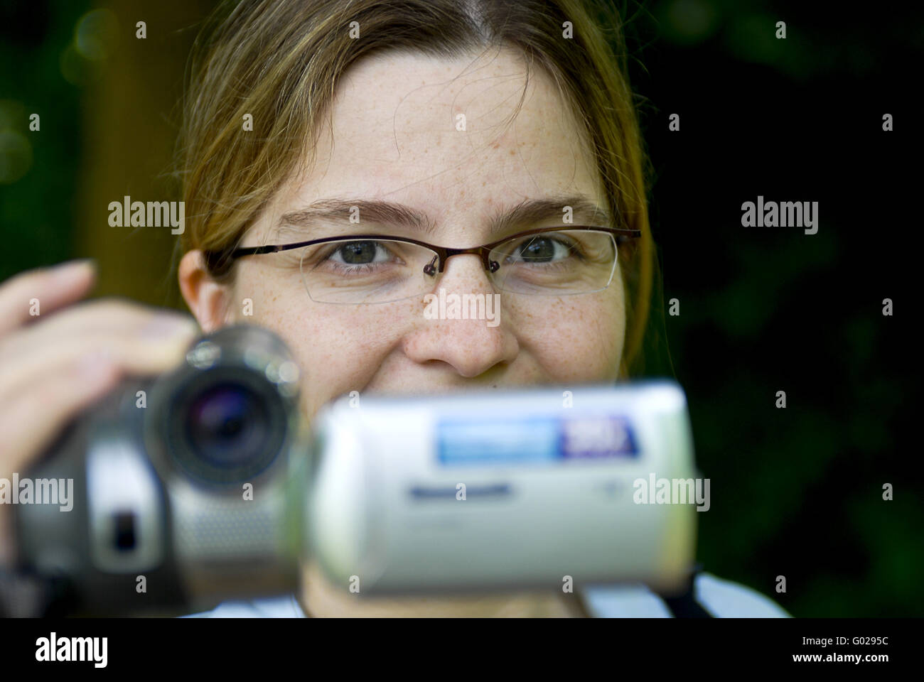 Young woman with a video camera while filming Stock Photo - Alamy
