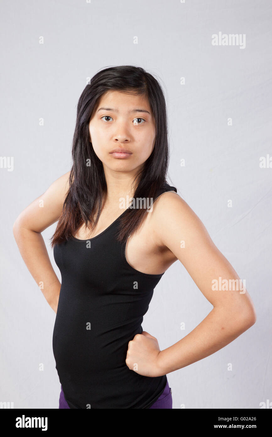 Lovely Asian woman looking thoughtfully at the camera with her hands on her hips Stock Photo - Alamy