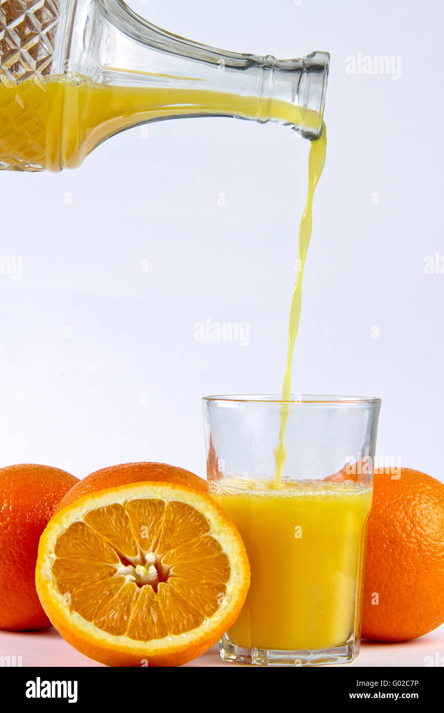 Orange juice pouring into glass Stock Photo - Alamy