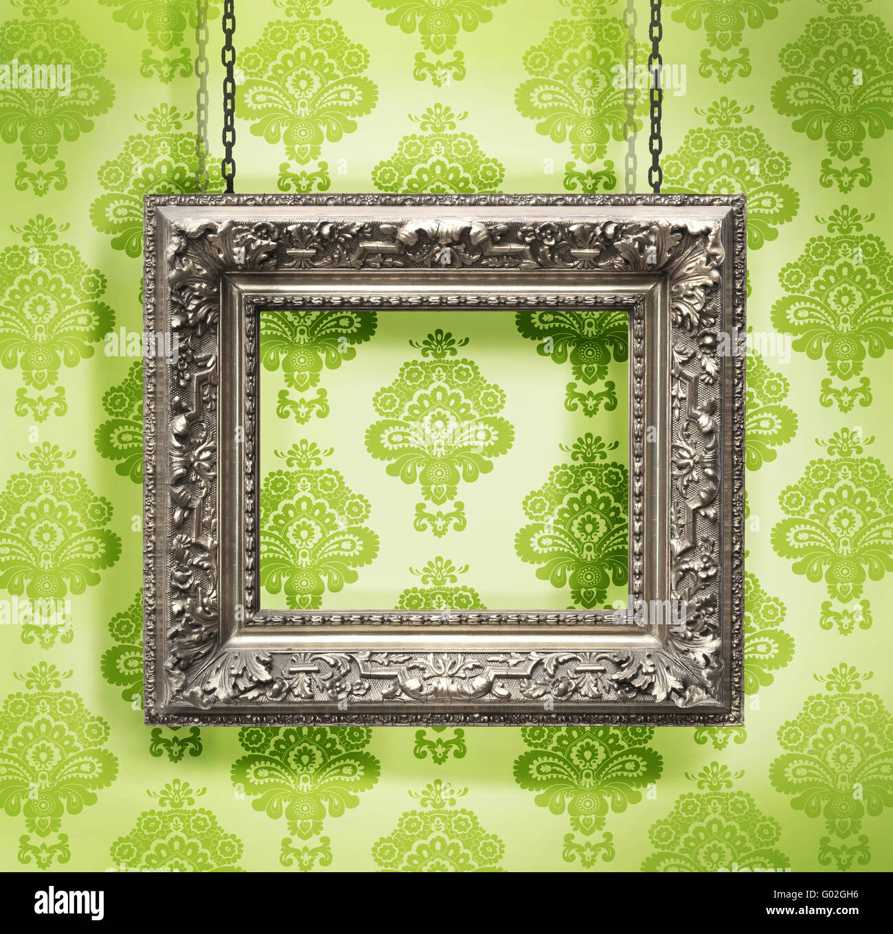 Silver picture frame hung against floral wallpaper background Stock ...