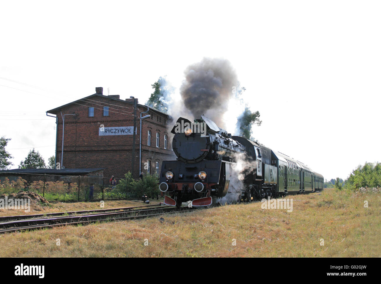 Old retro steam train starting from the small station Stock Photo - Alamy