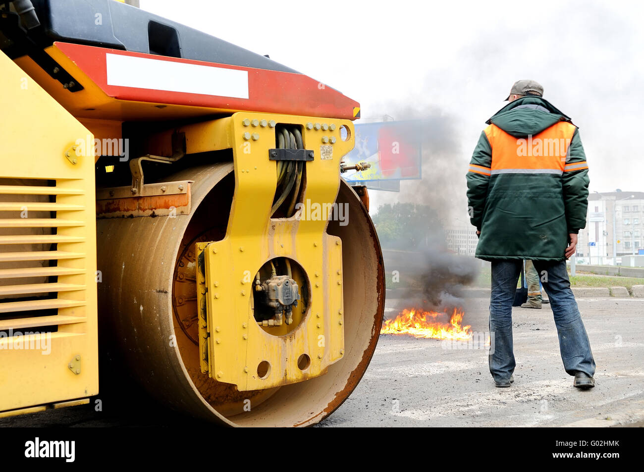 fire extinguishing by asphalt road roller compactor Stock Photo - Alamy