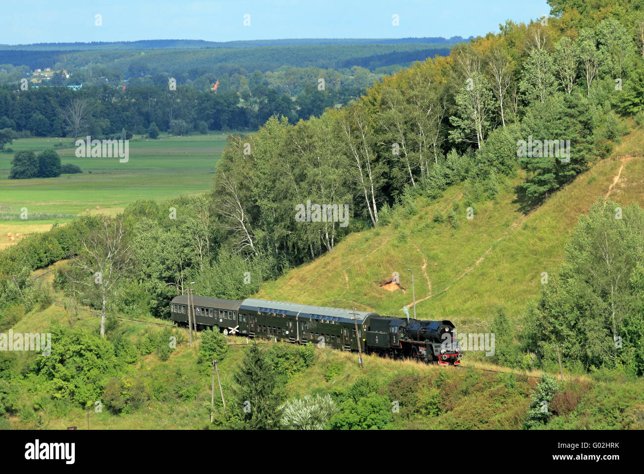 Beautiful hilly landscape with an old retro steam train Stock Photo - Alamy