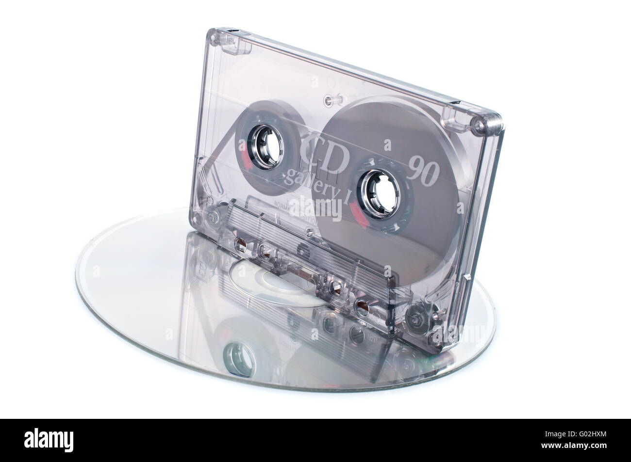 Analog audio tape cassette and digital compact disc on white background ...