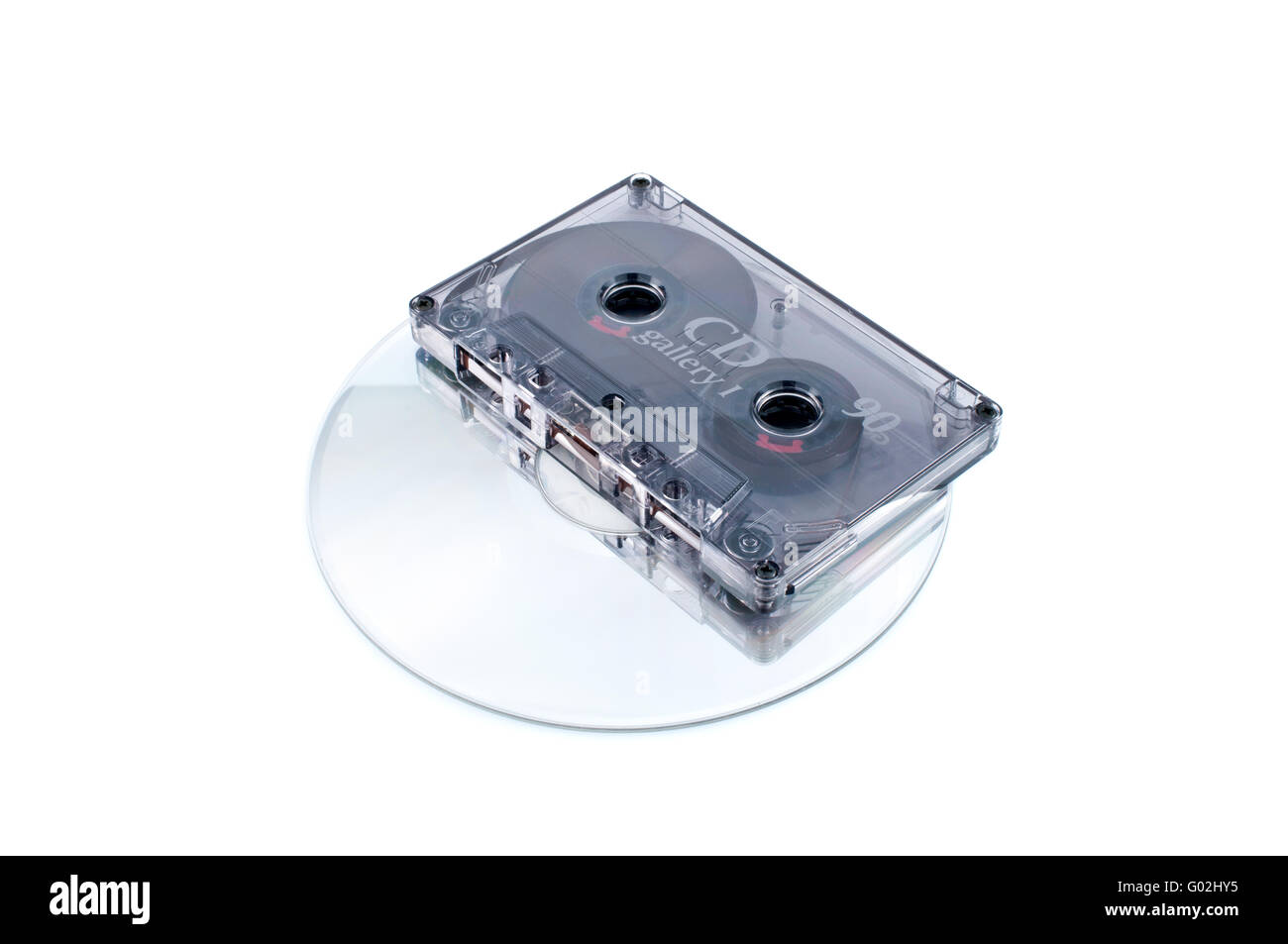 Analog audio tape cassette and digital compact disc on white background ...