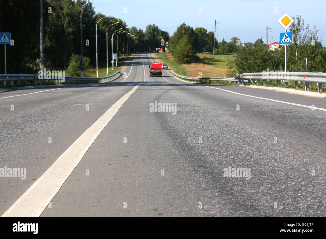 Red tow truck traveling on the road. Traffic signs Stock Photo - Alamy