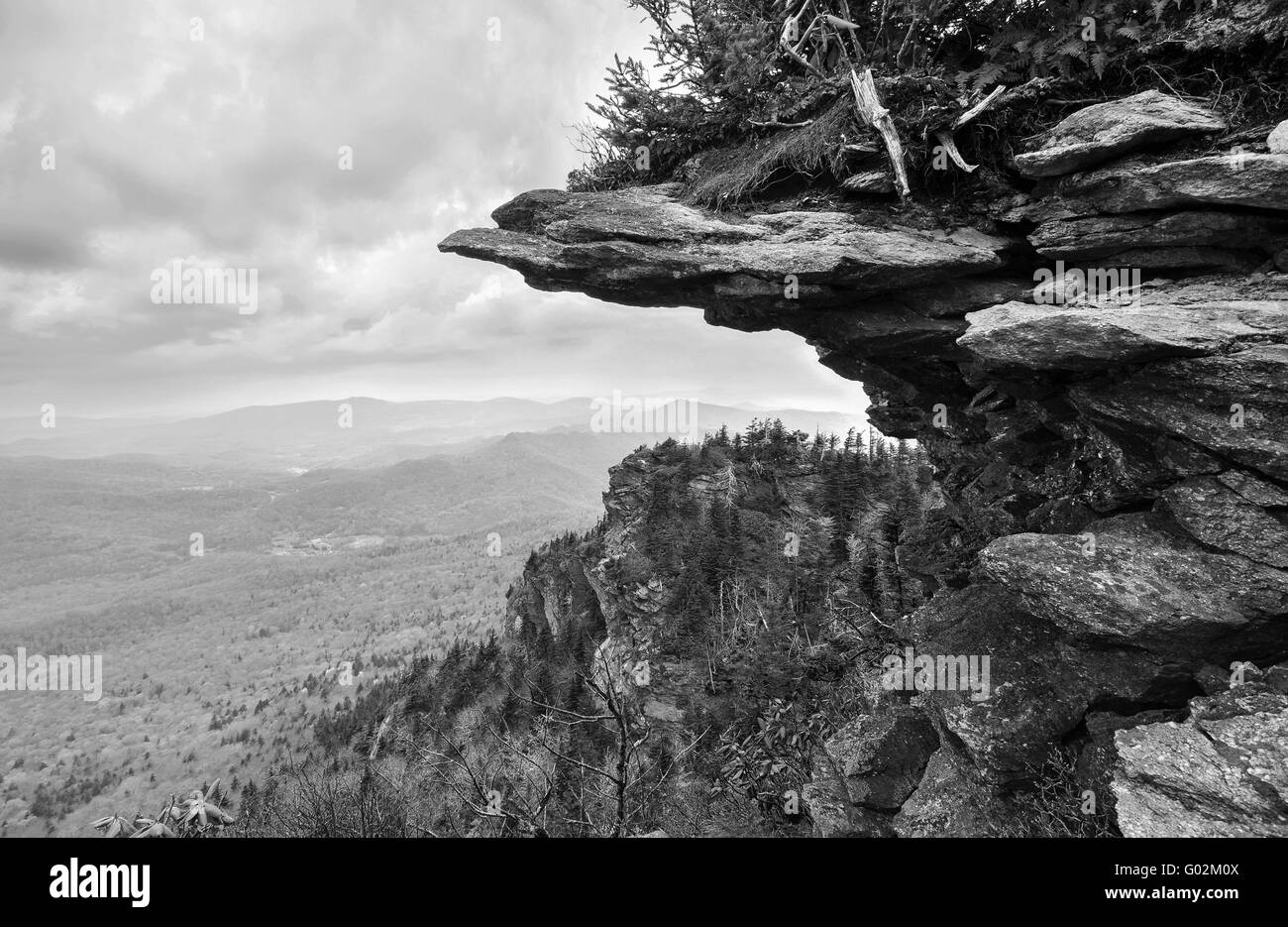 Black and white of a rocky weathered cliff jutting out from an ...