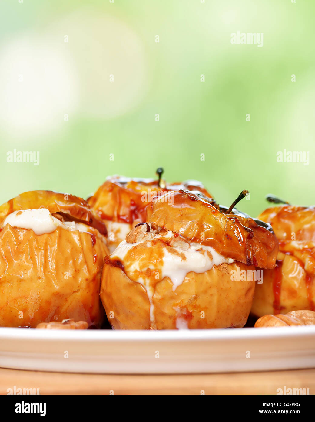 Closeup photo of a tasty baked apples stuffed with cream honey and nuts ...
