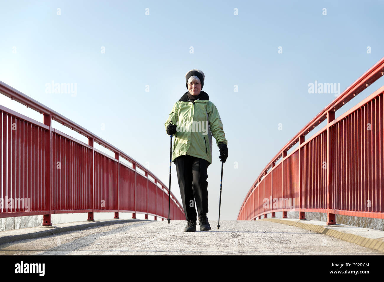 Woman running during Nordic Walking over a bridge Stock Photo - Alamy
