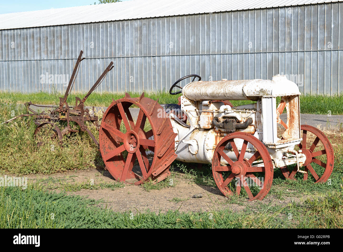 Old vintage tractor rusting away on grass to illustrate the concept of ...
