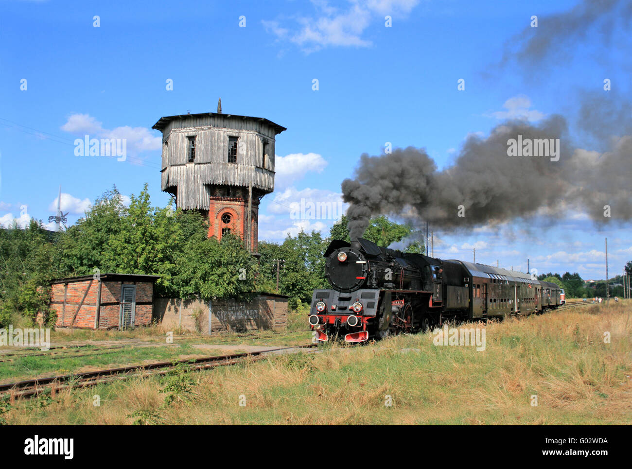Old retro steam train starting from the small station Stock Photo - Alamy