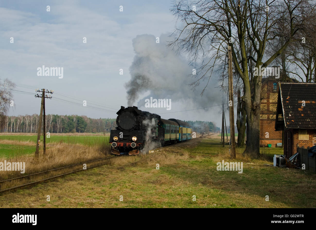 Steam passenger train starting from the small station Stock Photo - Alamy