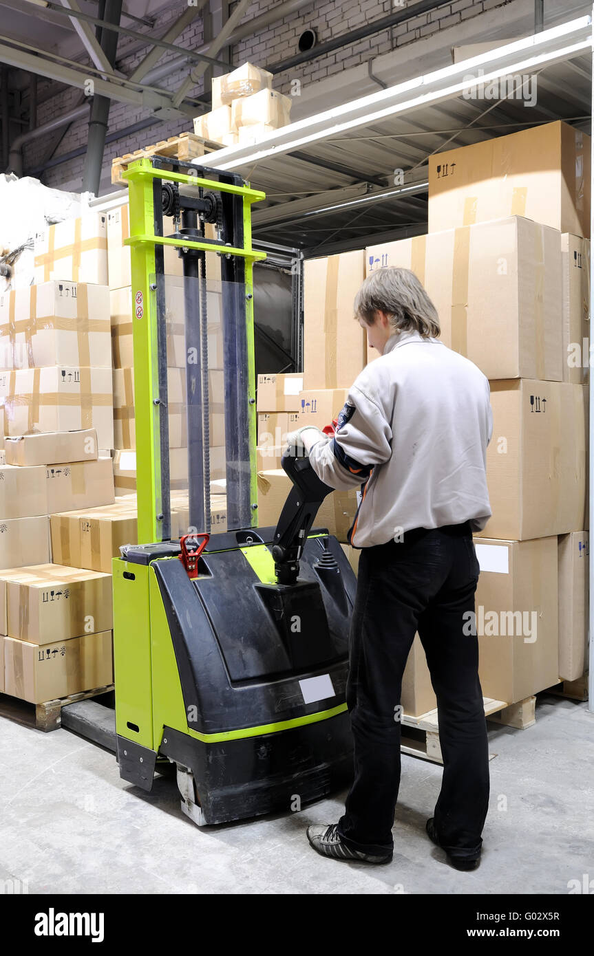 Operator of electric forklift stacker in warehouse Stock Photo - Alamy