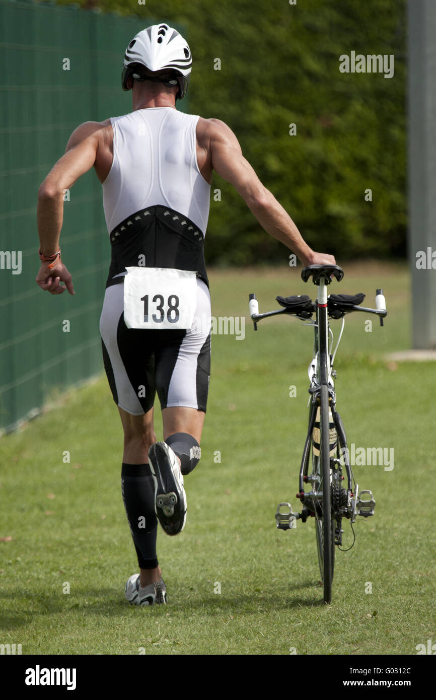 Triathlete pushing his bike Stock Photo - Alamy