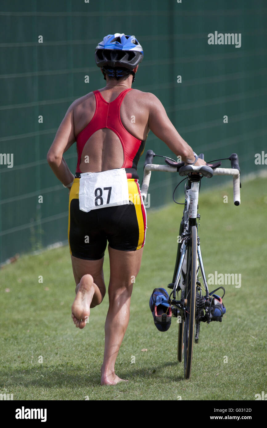 Triathlete pushing his bike Stock Photo - Alamy