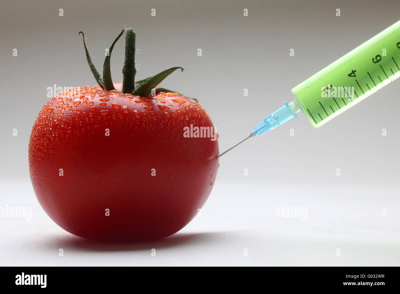 Injection into fresh red tomato Stock Photo - Alamy