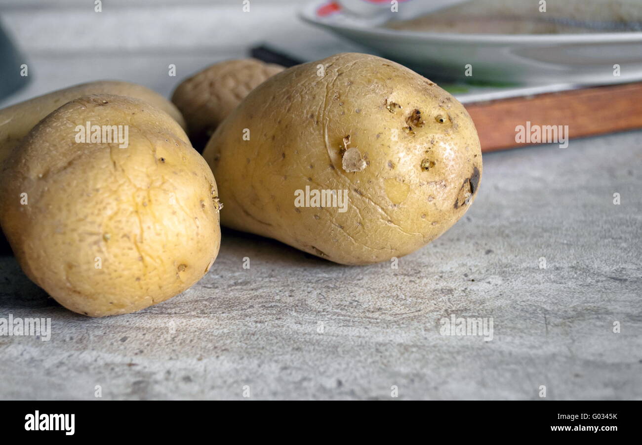 Whole healthy potatoes in a kitchen background Stock Photo - Alamy