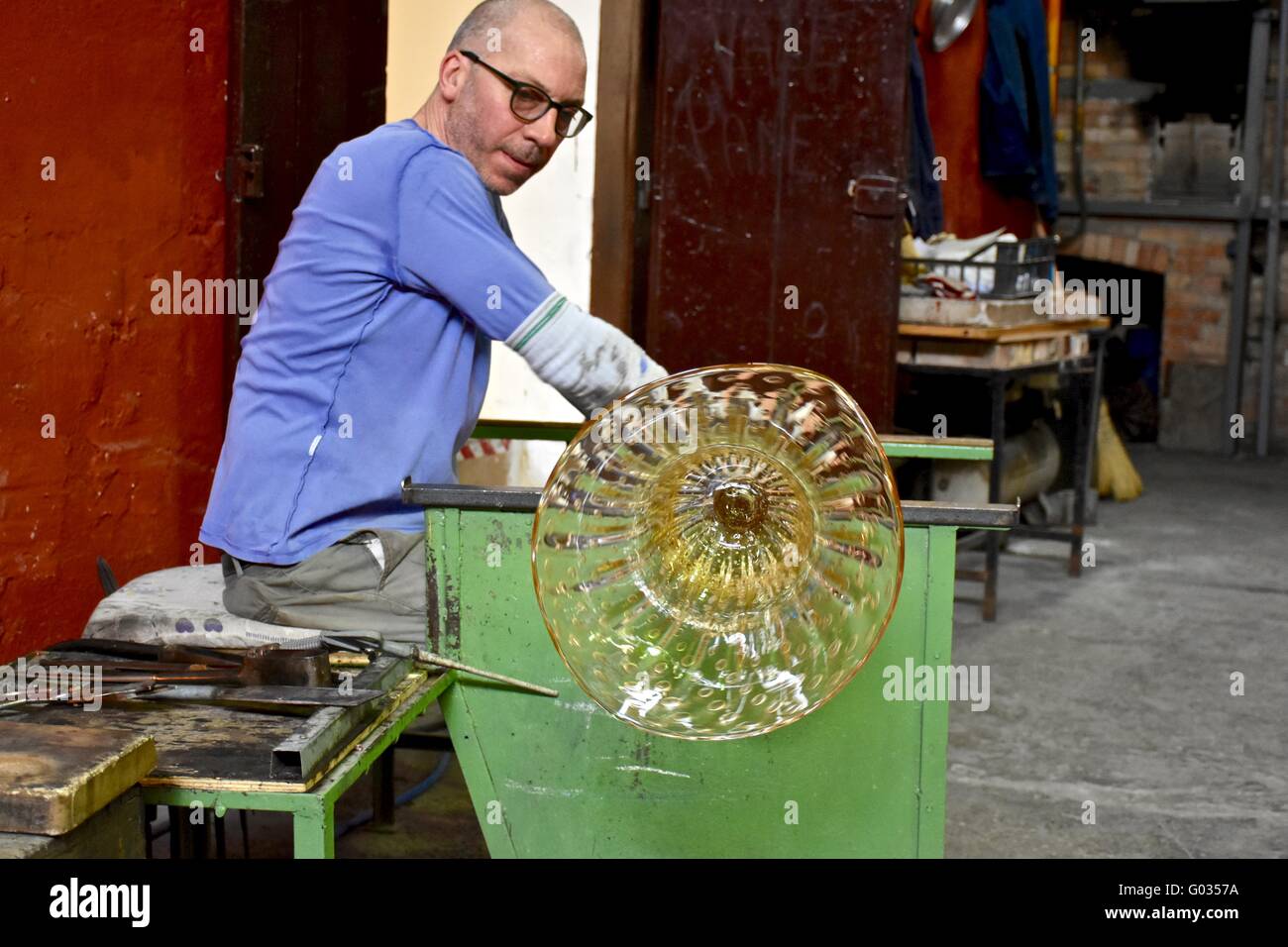 Glass blowers making glass at the glass factory on Murano island, Italy ...