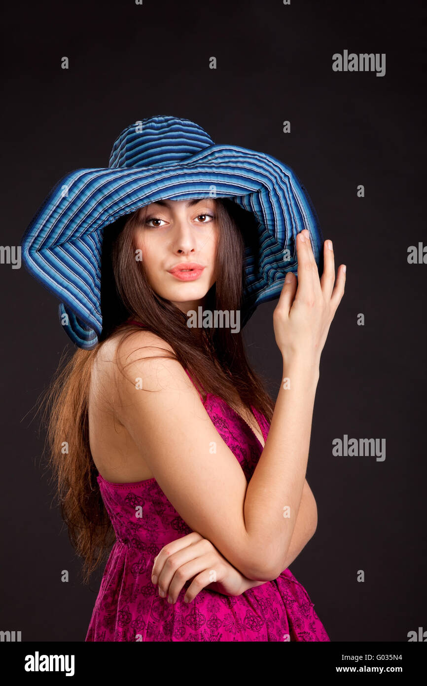 Pretty young smiling girl in cap on dark background Stock Photo - Alamy