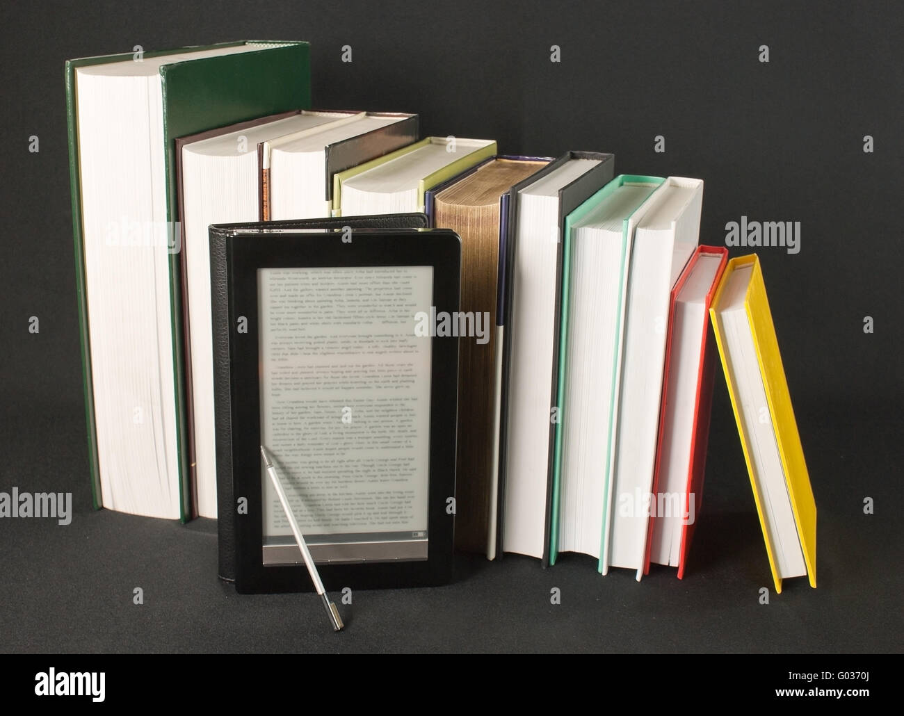 Row of printed books with electronic book reader o Stock Photo - Alamy