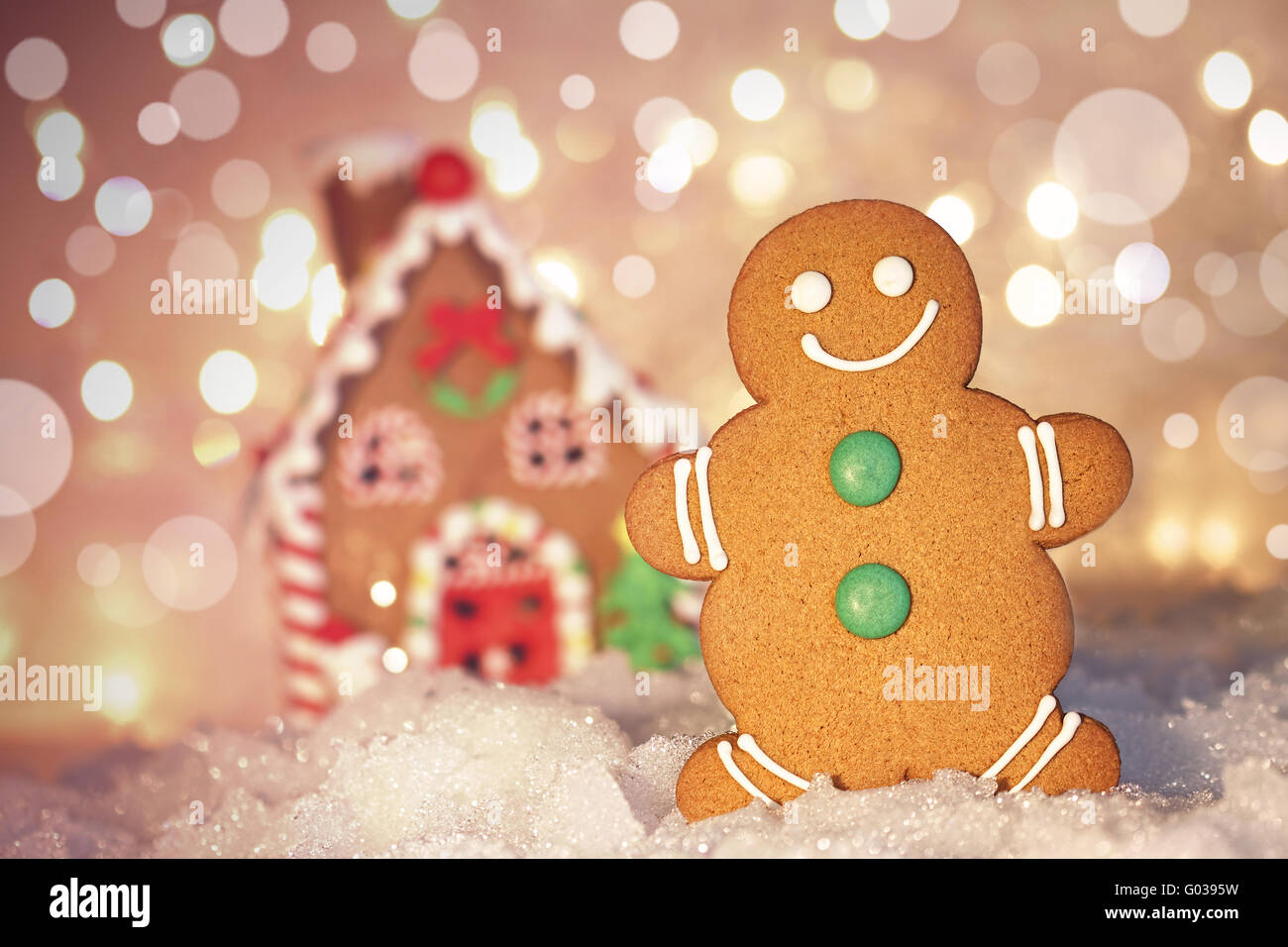 Gingerbread man cookie standing in snow beside hou Stock Photo - Alamy