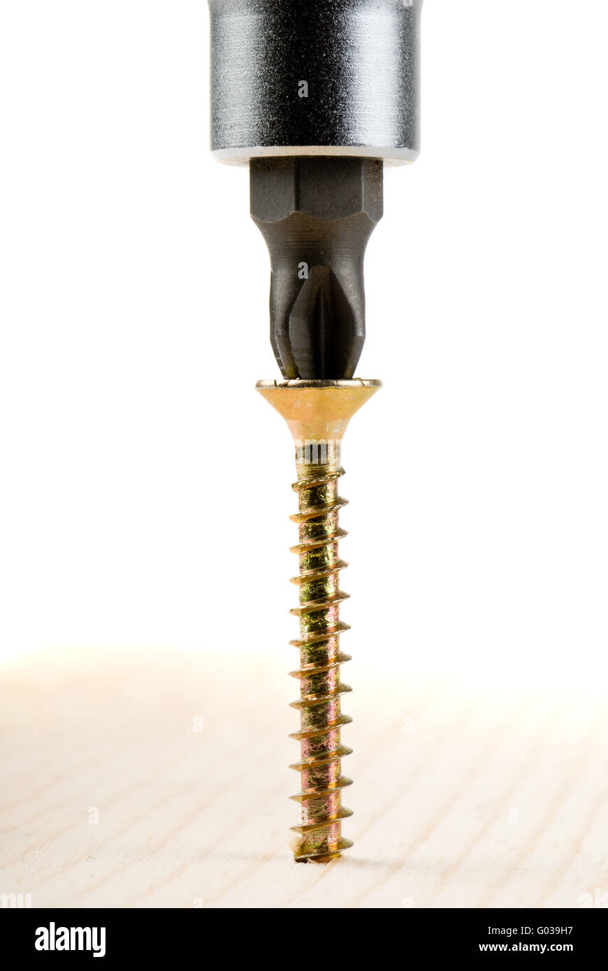Closeup image of screwdriver and single screw in board on white ...