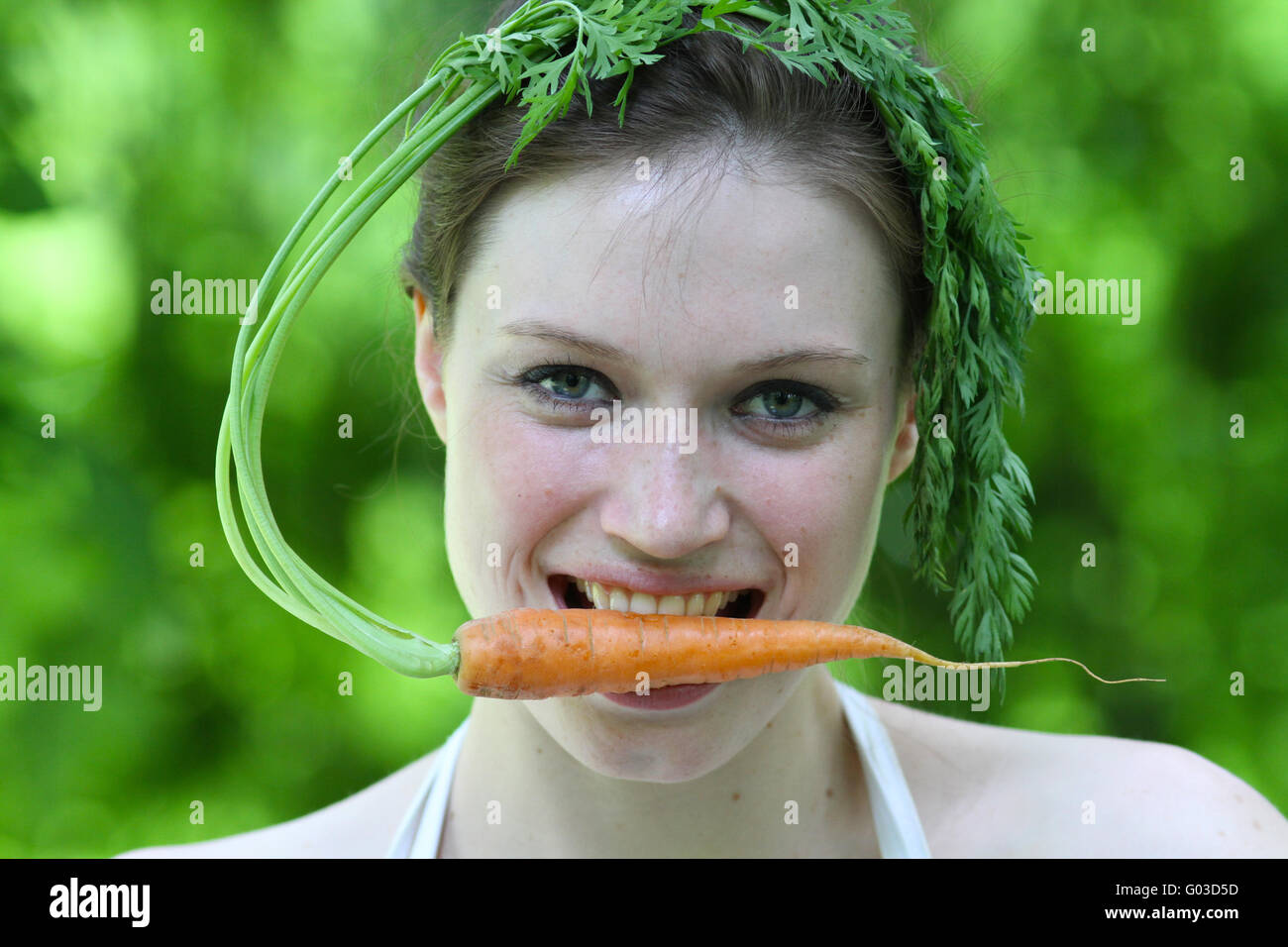 Woman bites in to a carrot Stock Photo - Alamy