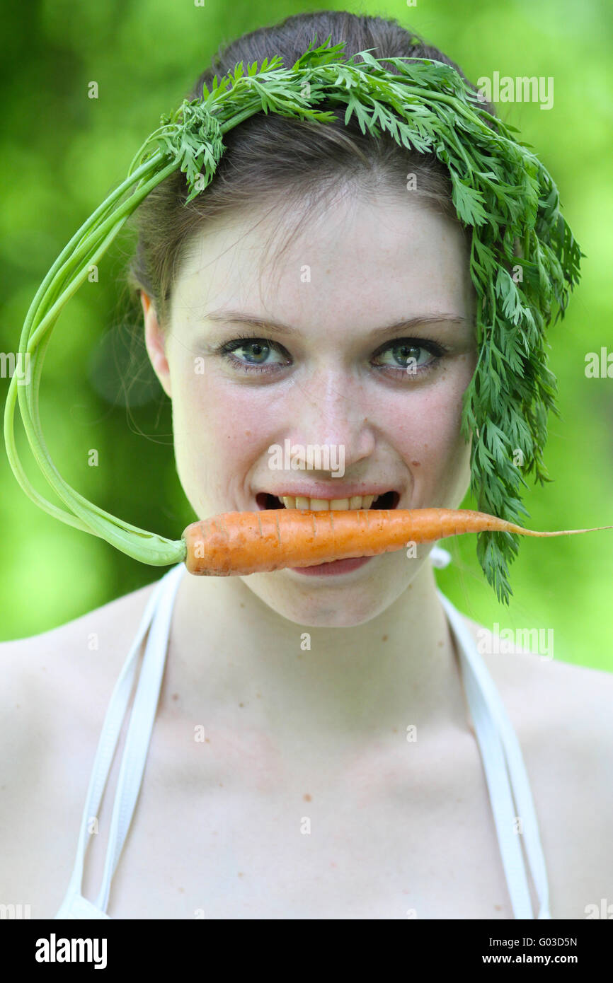 Woman bites in to a carrot Stock Photo - Alamy