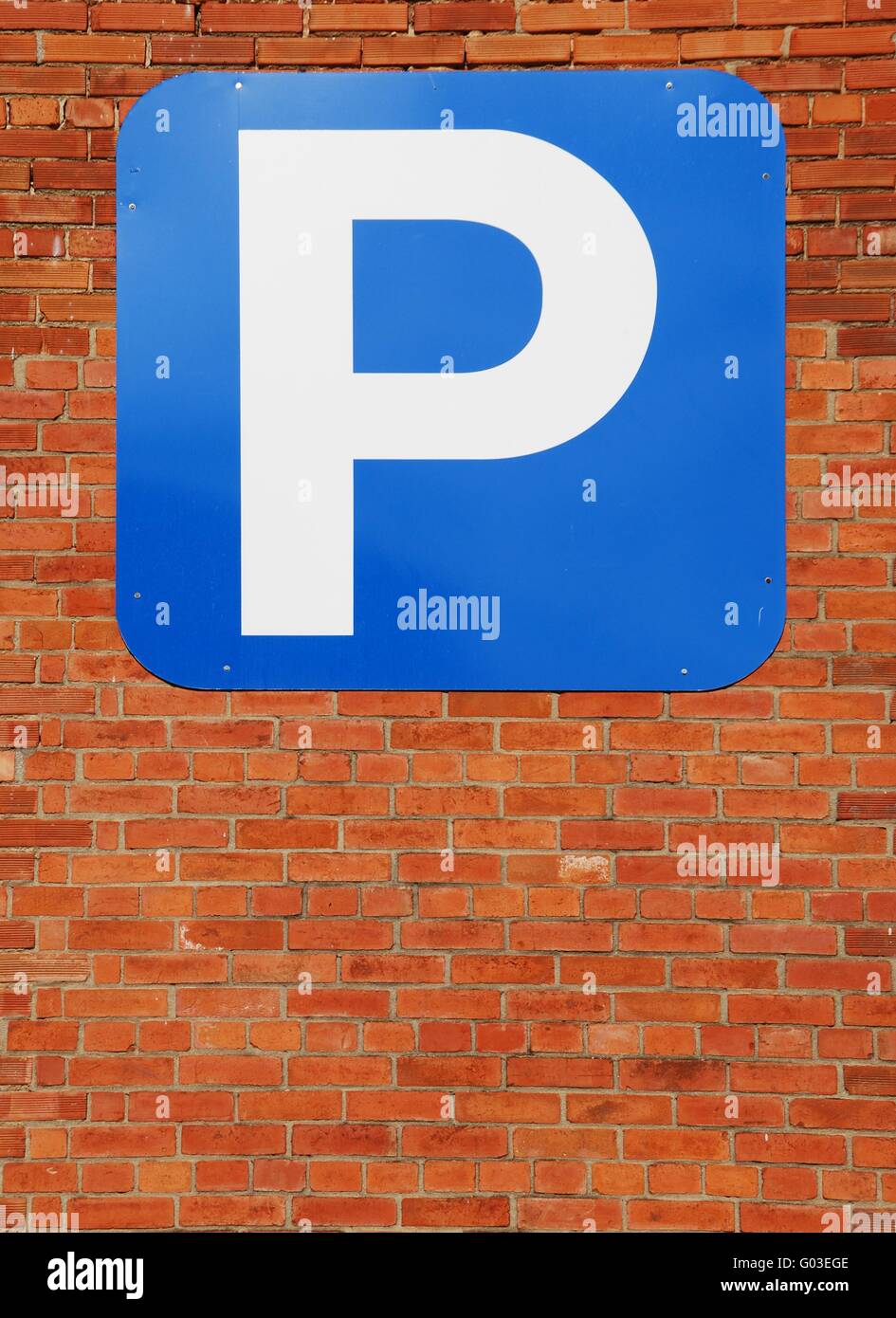 blue parking sign at a red brick wall background Stock Photo - Alamy