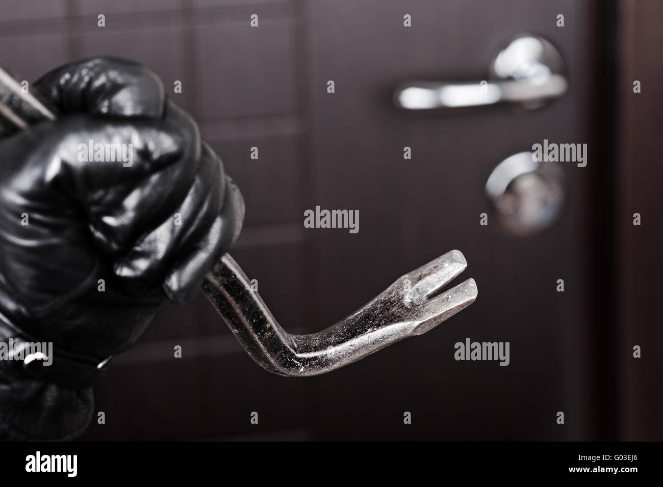 Burglar hand holding crowbar break opening door Stock Photo - Alamy
