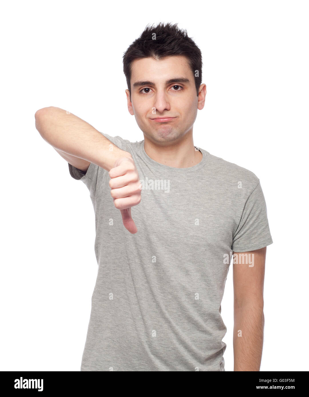 handsome young man with thumbs down on an isolated white background ...