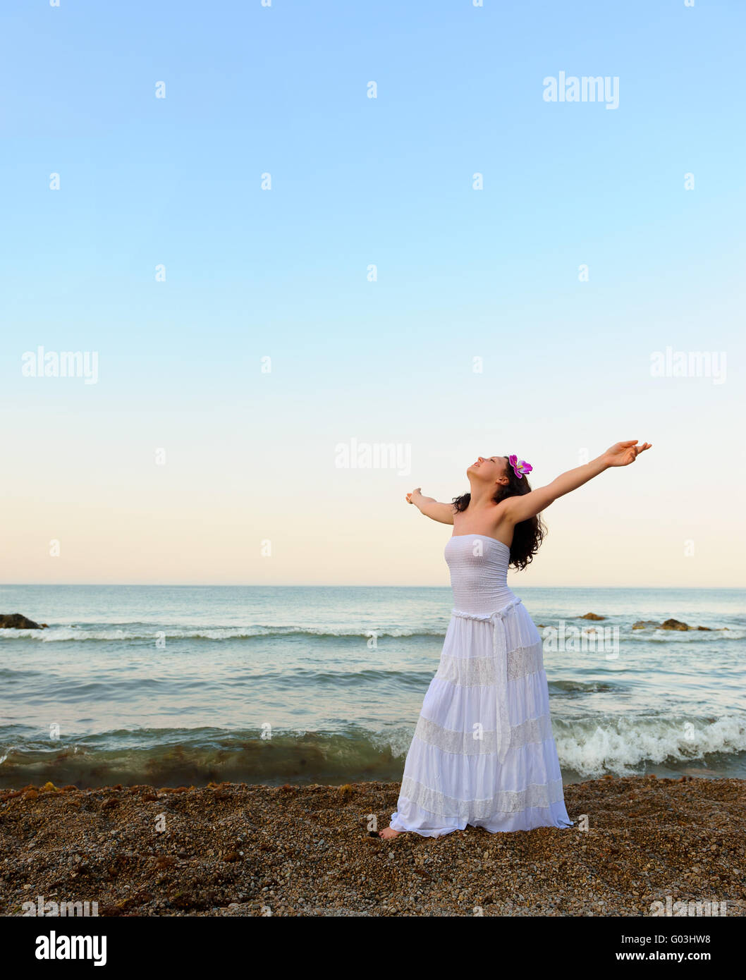 The woman in a white sundress on seacoast with open hands Stock Photo ...
