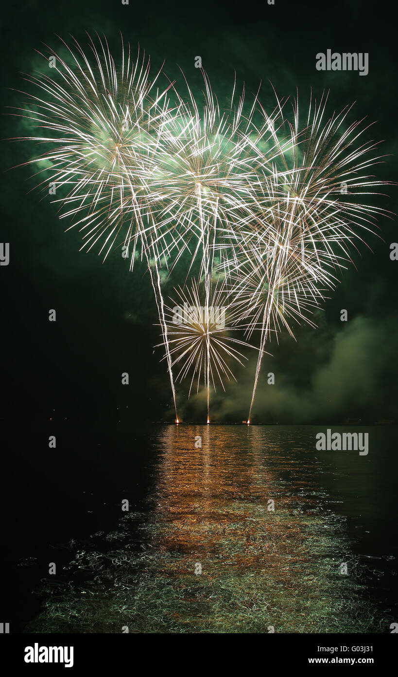 Colorful fireworks with reflection on lake and night sky in background ...