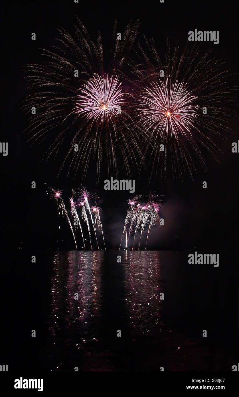 Colorful fireworks with reflection on lake and night sky in background ...